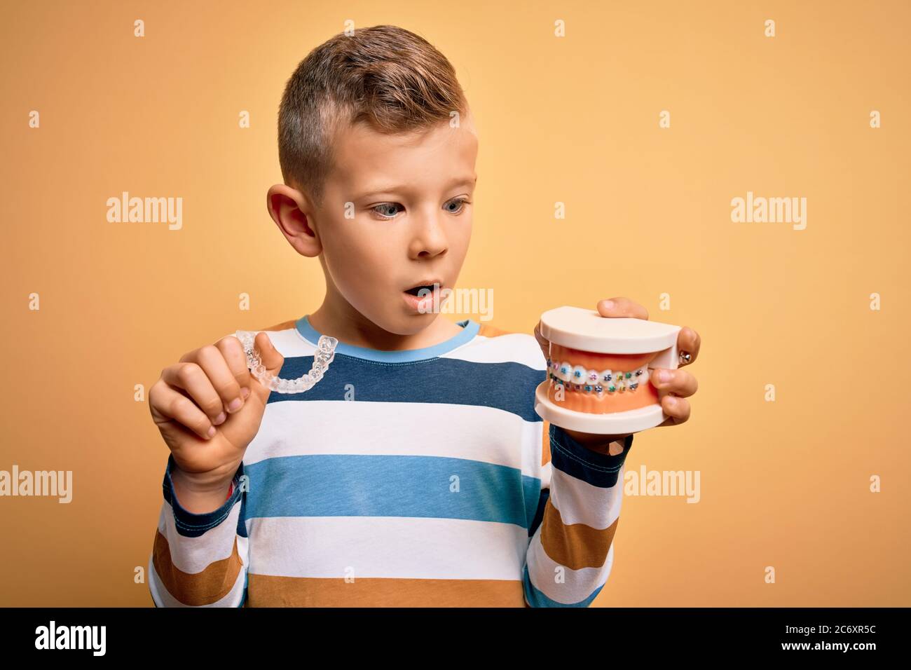 Little kid boy holding professional orthodontic denture with metal ...