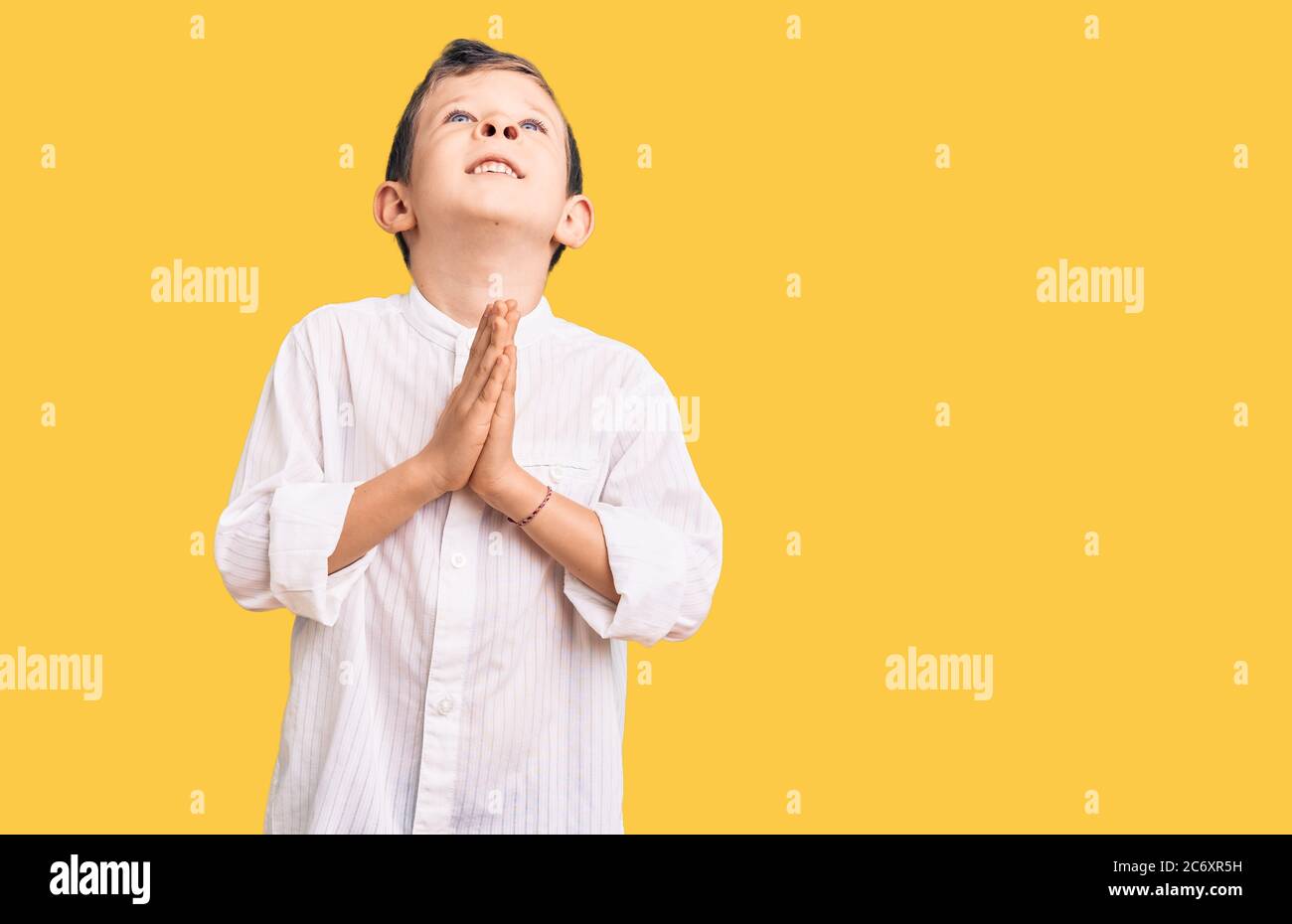 Cute blond kid wearing elegant shirt begging and praying with hands ...