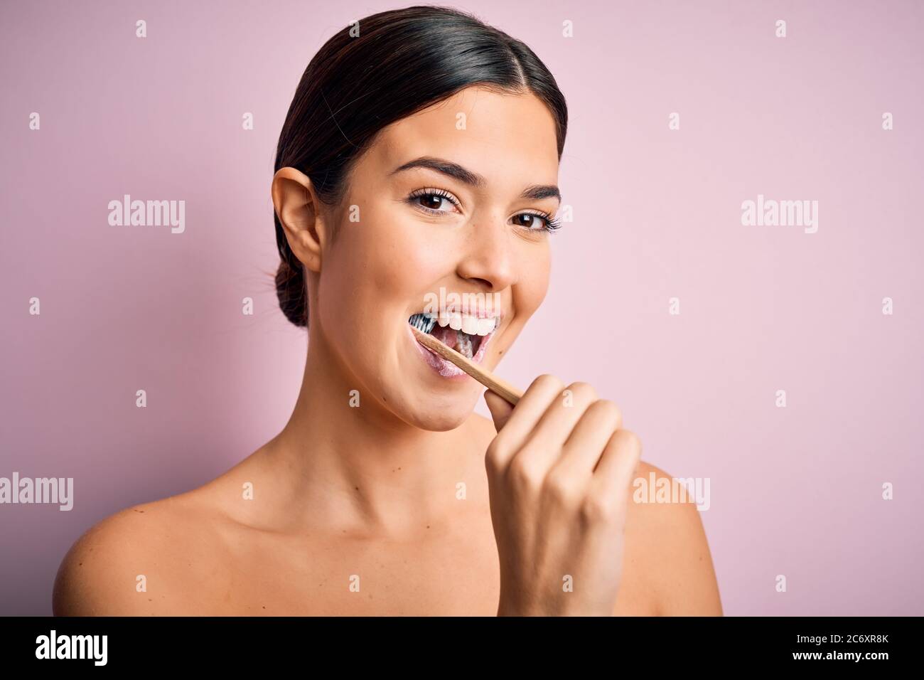 Young beautiful brunette woman brushing her teeth using tooth brush and ...