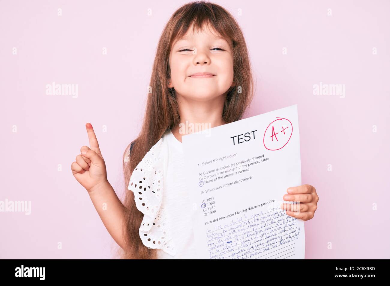 Little caucasian kid girl with long hair showing a passed exam from ...