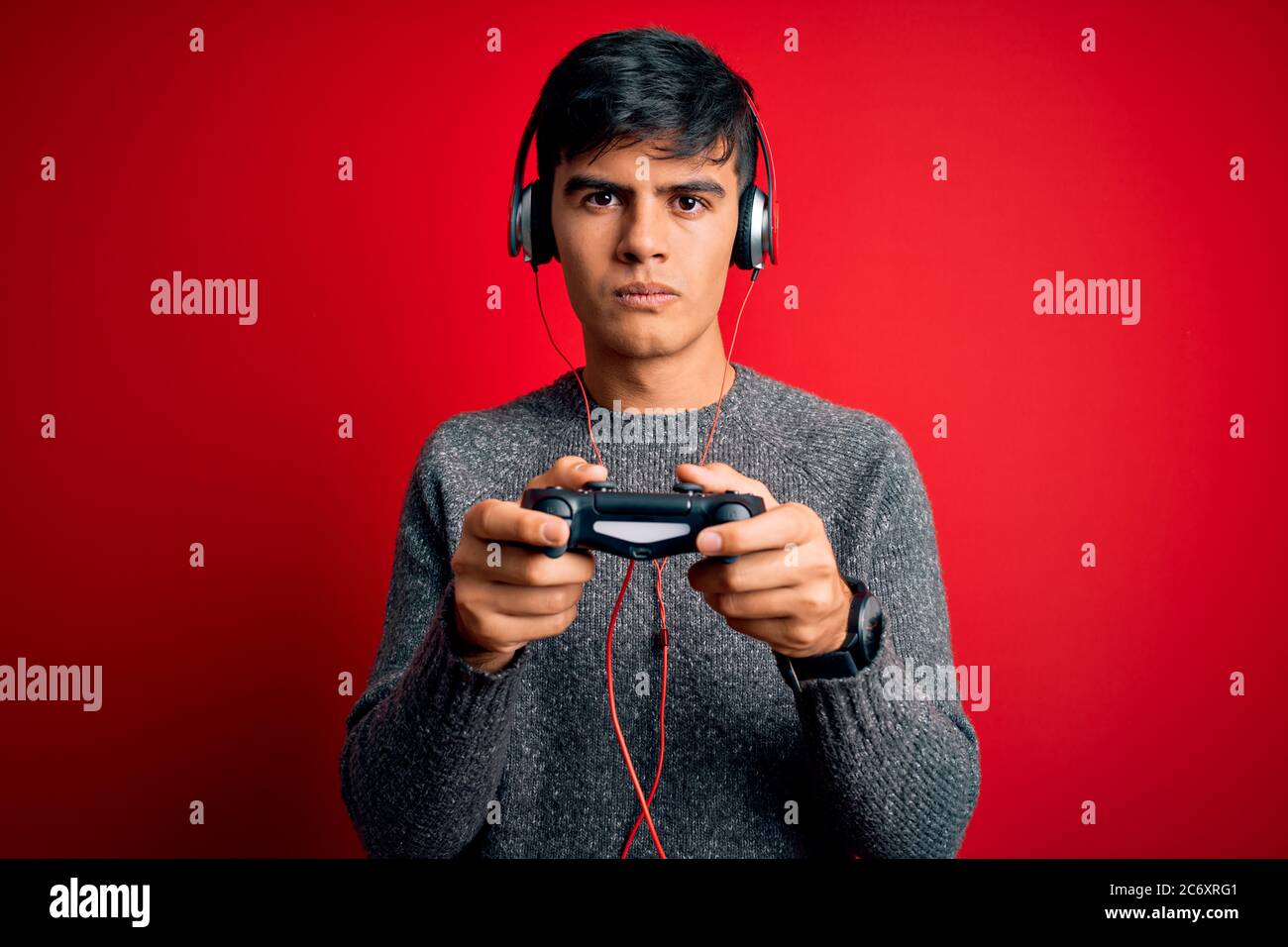 Young handsome gamer man playing video game using joystick and ...