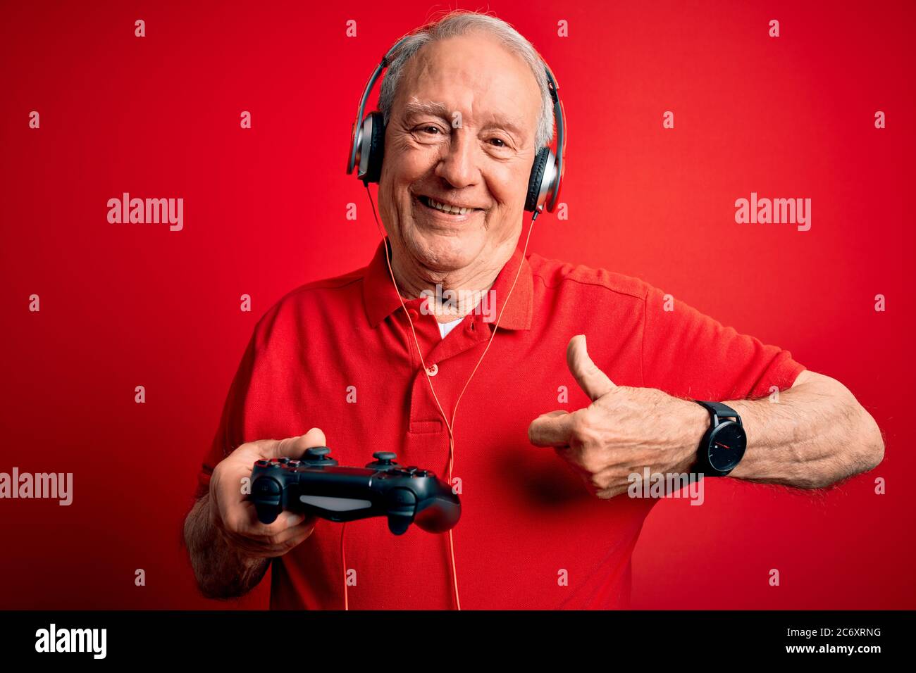 Senior grey haired gamer man playing video games using gamepad joystick ...