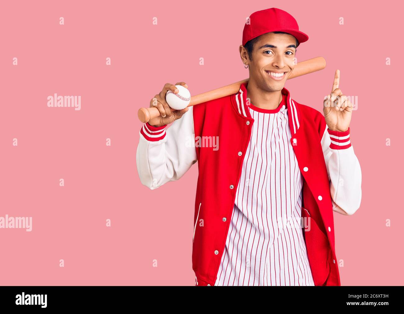 Young african amercian man playing baseball holding bat and ball ...