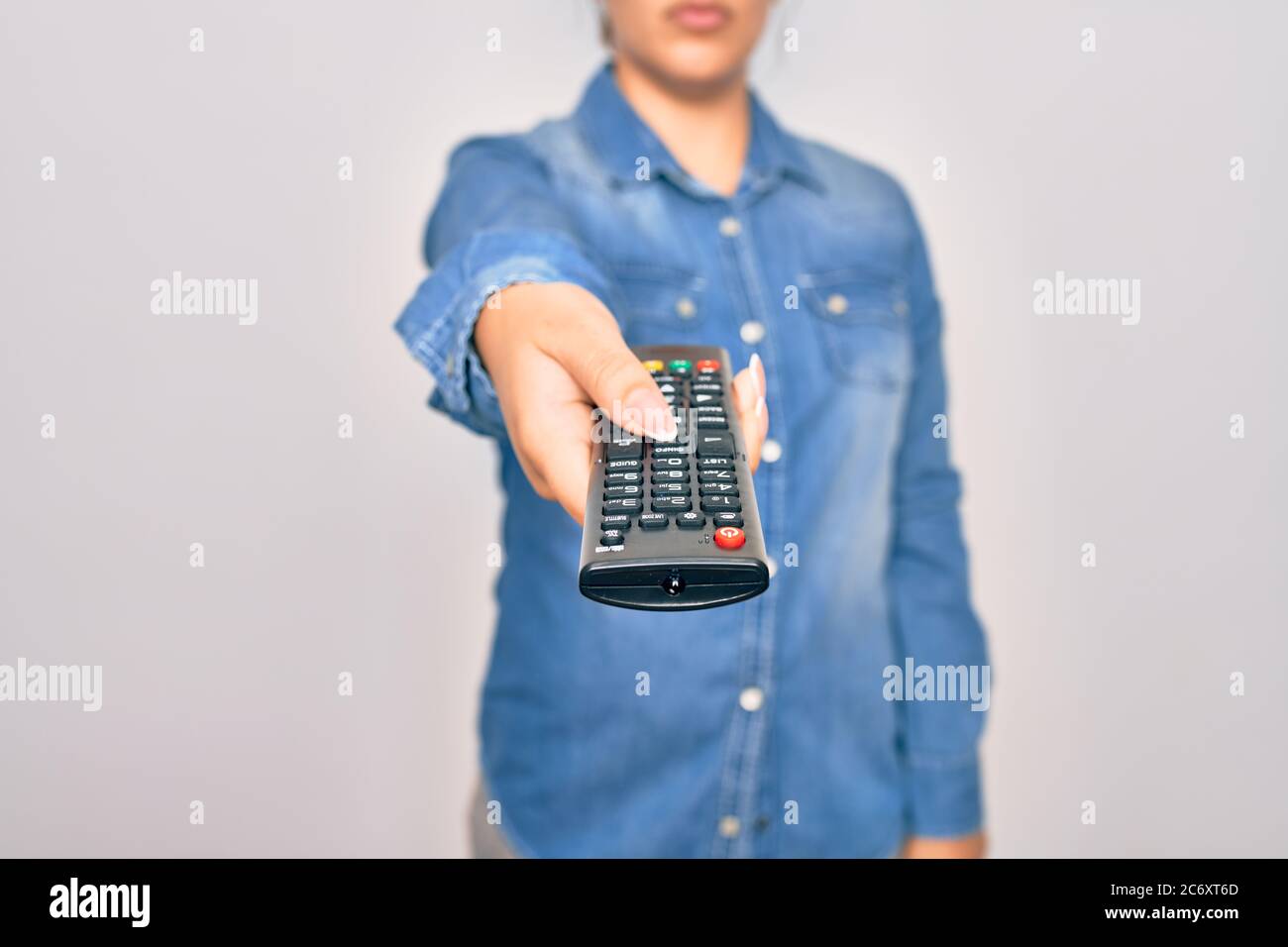 Woman changing television channel holding tv remote control. Standing ...