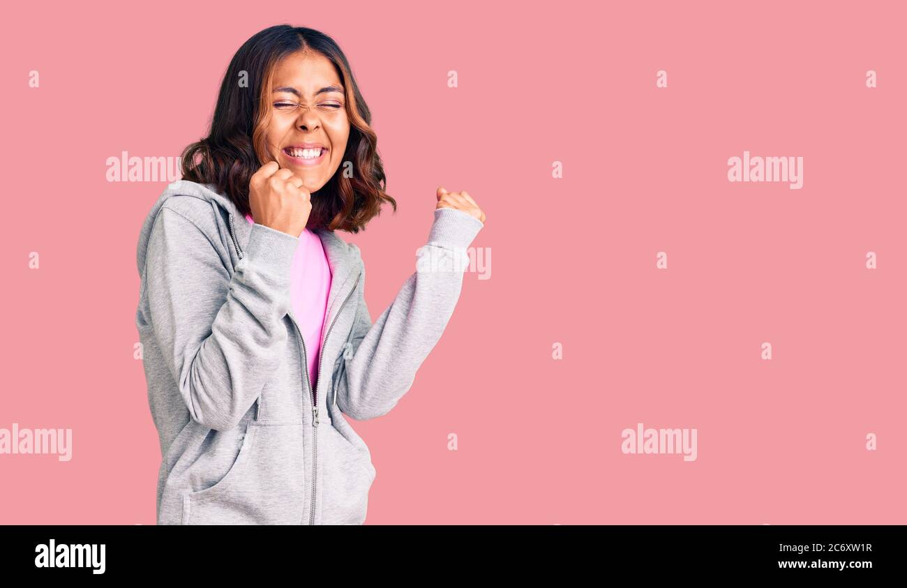 Young beautiful mixed race woman wearing casual sporty clothes excited ...