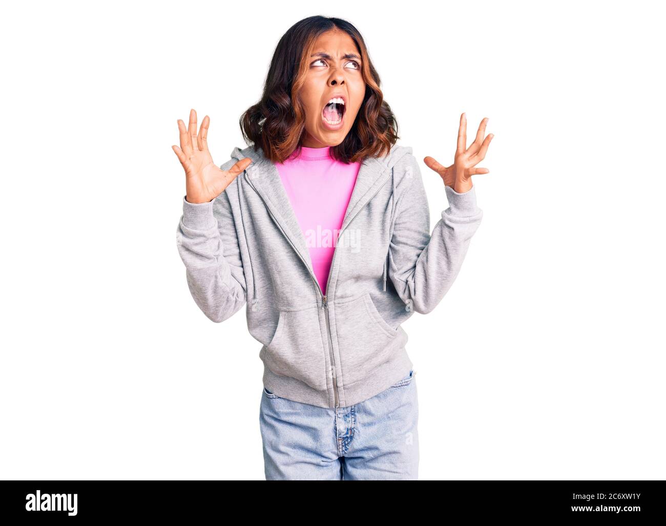 Young beautiful mixed race woman wearing casual sporty clothes crazy ...