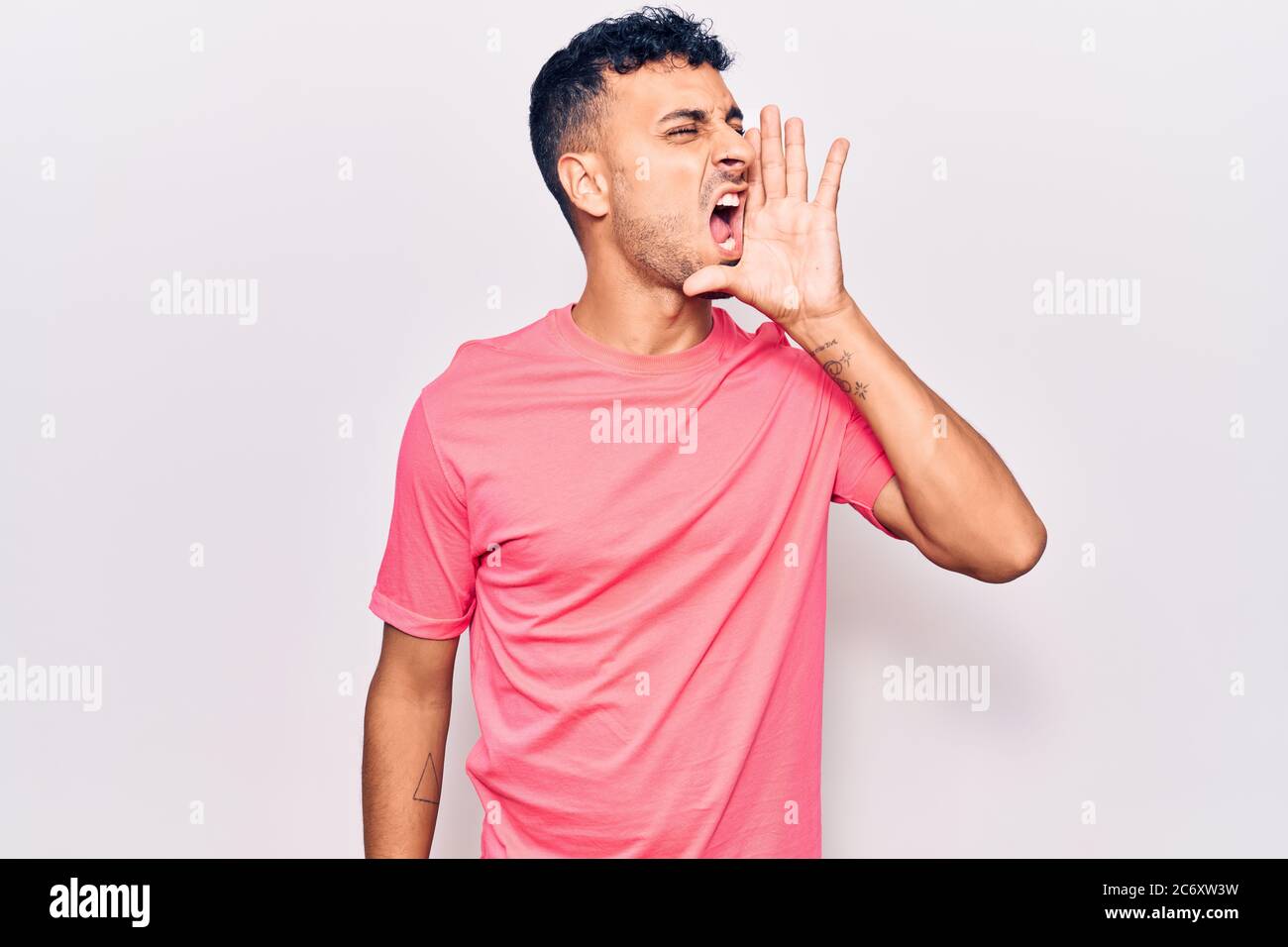 Young hispanic man wearing casual clothes shouting and screaming loud ...