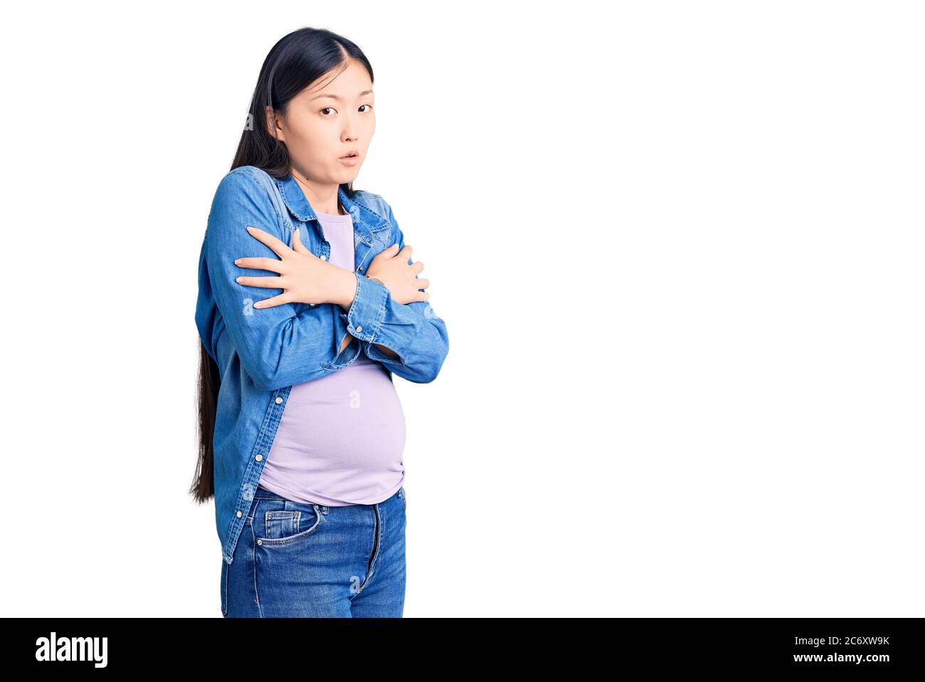 Young beautiful chinese woman pregnant expecting baby shaking and ...