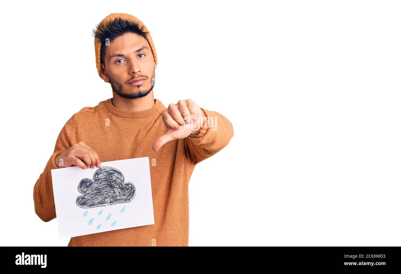 Handsome latin american young man holding rain draw with angry face ...