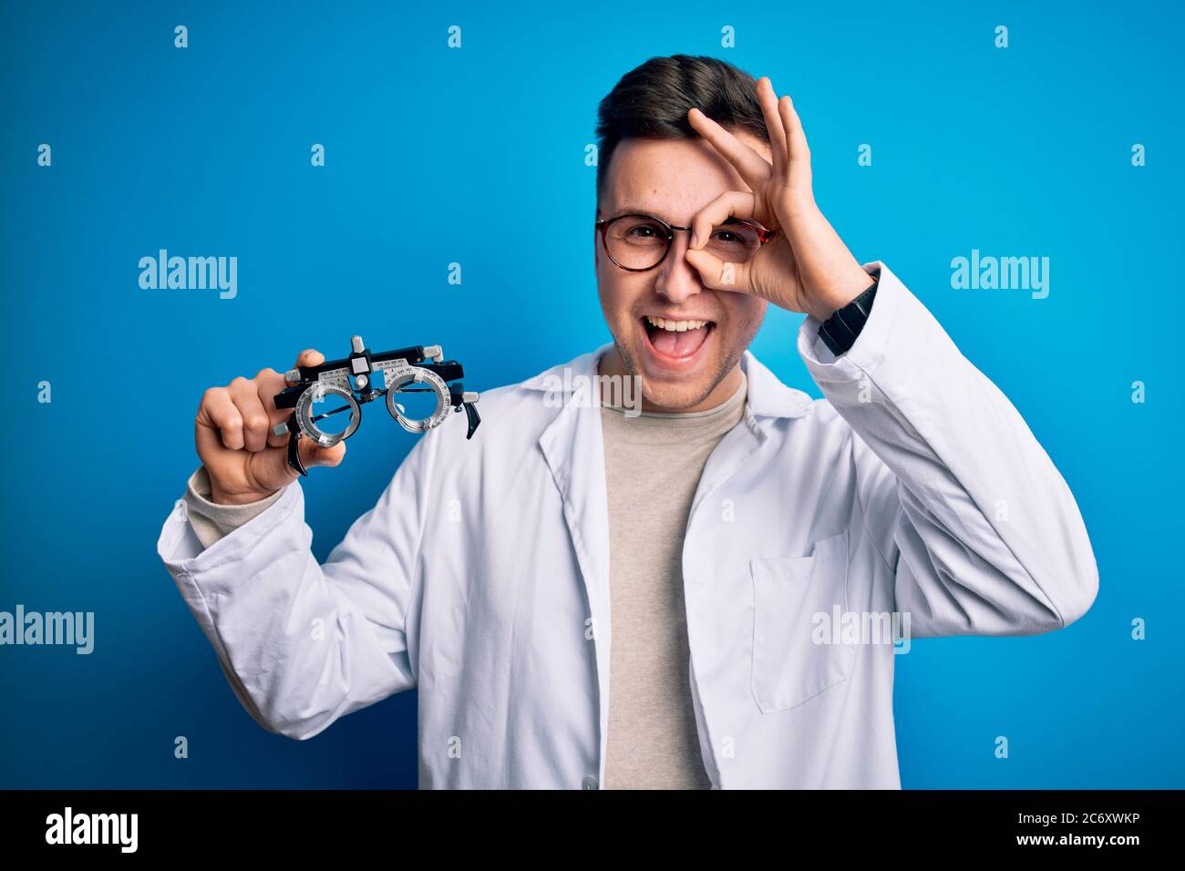 Young handsome professional optic man holding optometrical glasses over ...