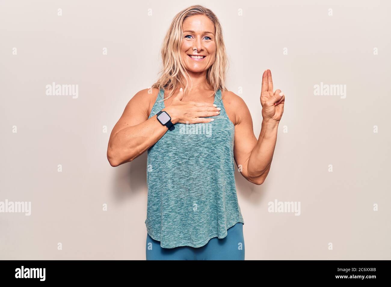 Middle age caucasian blonde woman wearing sportswear smiling swearing ...