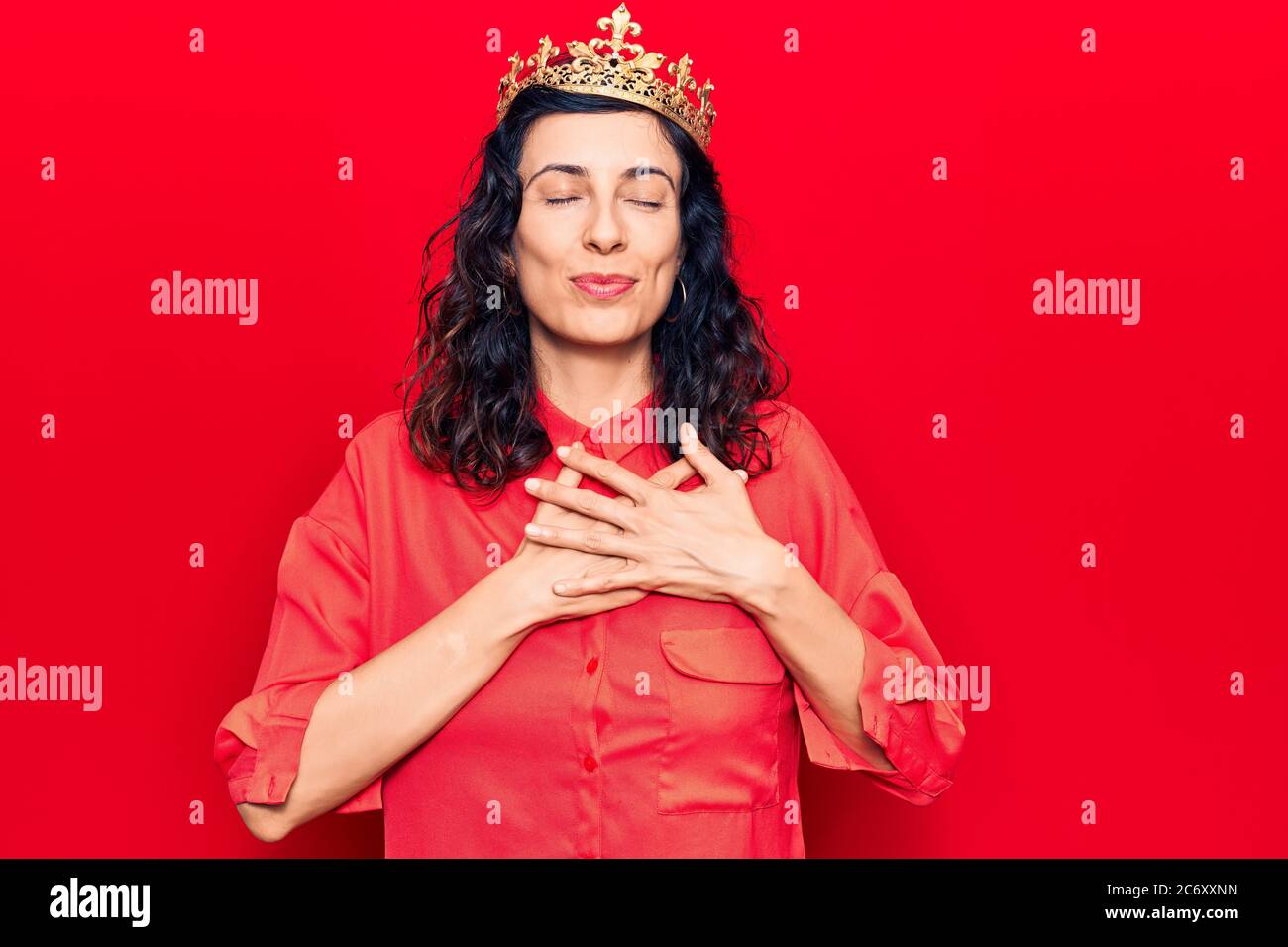 Young beautiful hispanic woman wearing princess crown smiling with ...