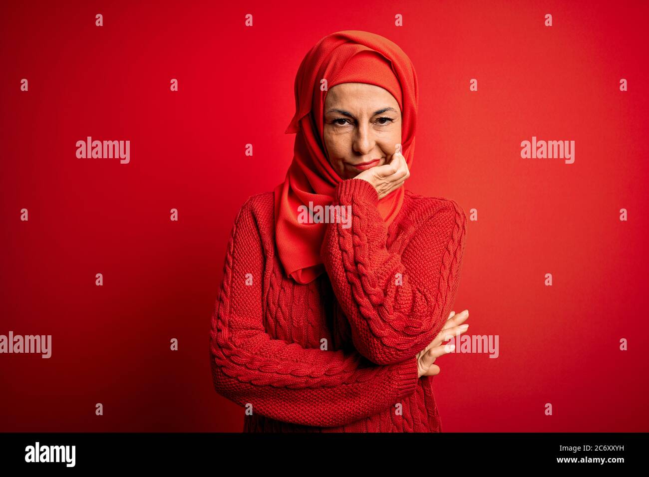 Middle age woman wearing traditional muslim hijab standing over ...