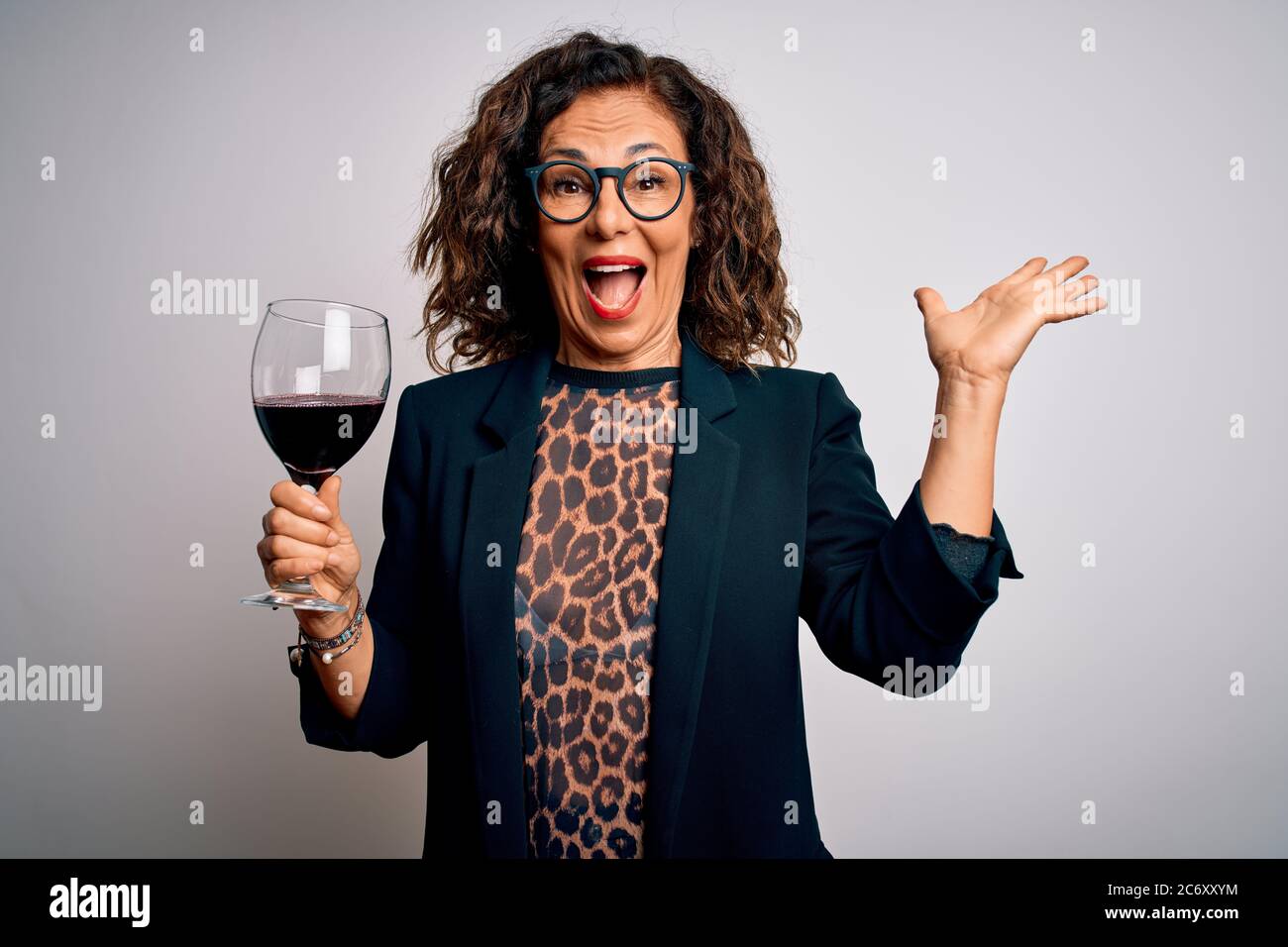 Middle age brunette woman drinking glass of red wine over isolated ...