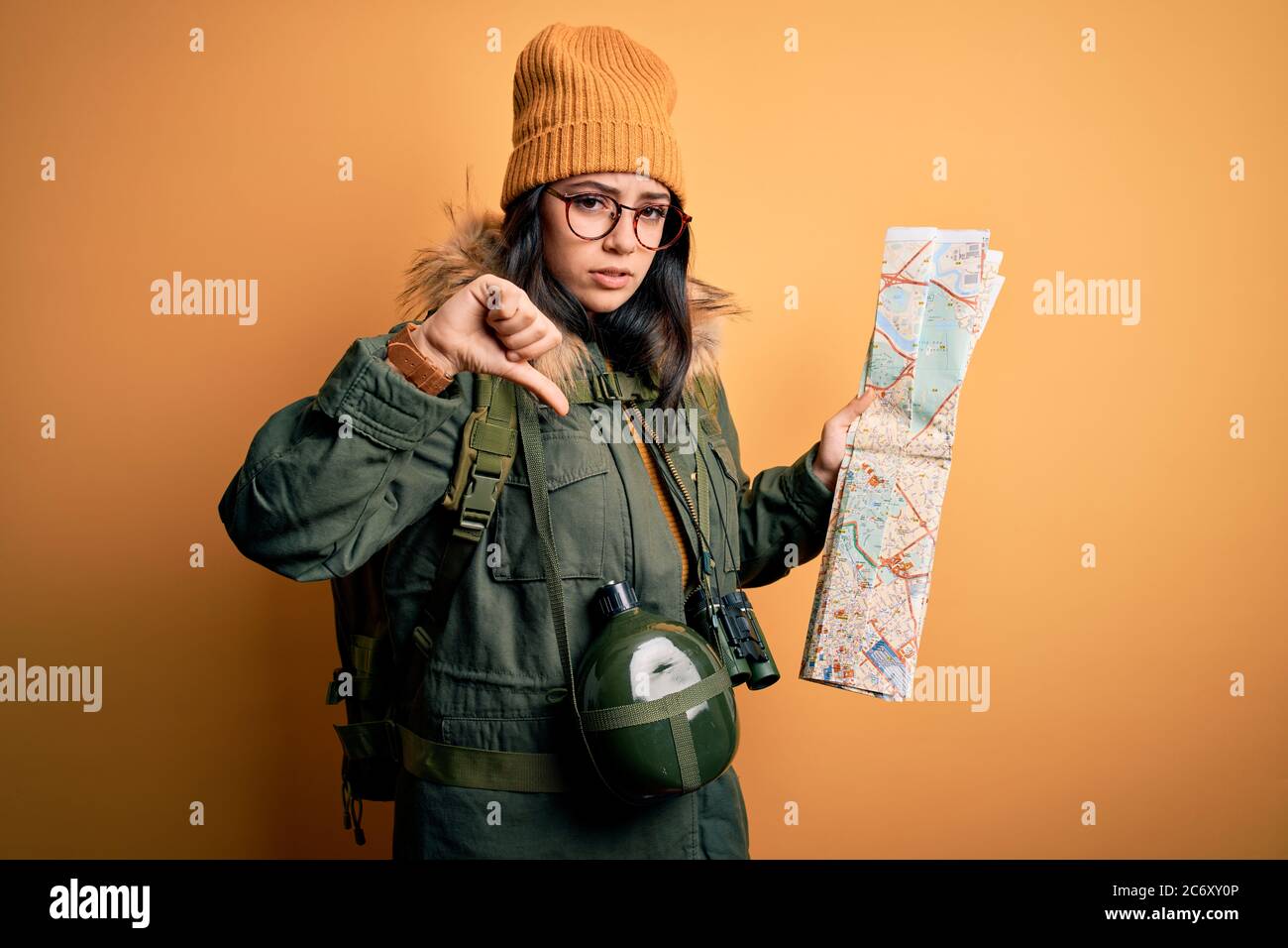 Young hiker woman wearing hiking backpack looking at tourist map over ...