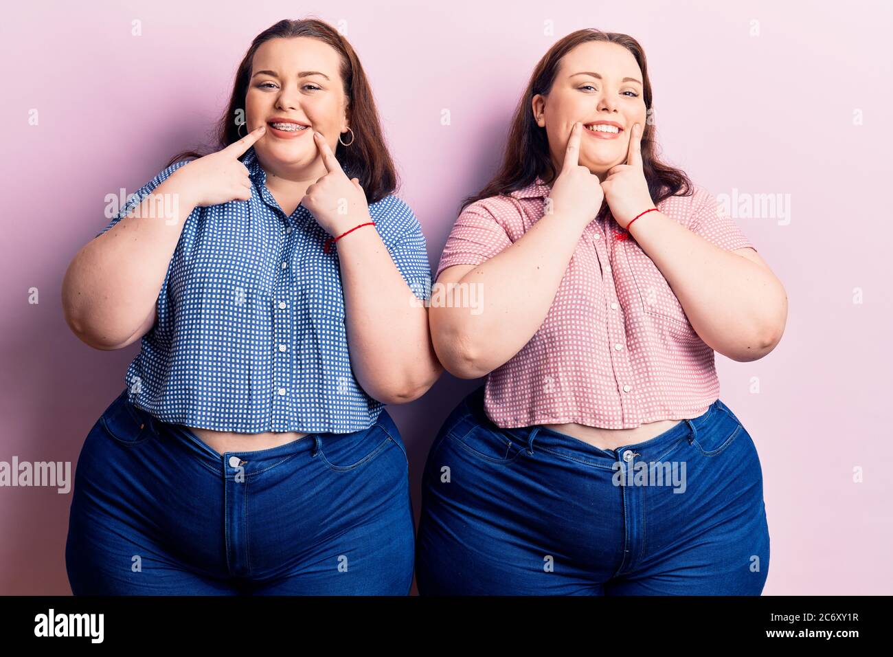 Young plus size twins wearing casual clothes smiling with open mouth ...