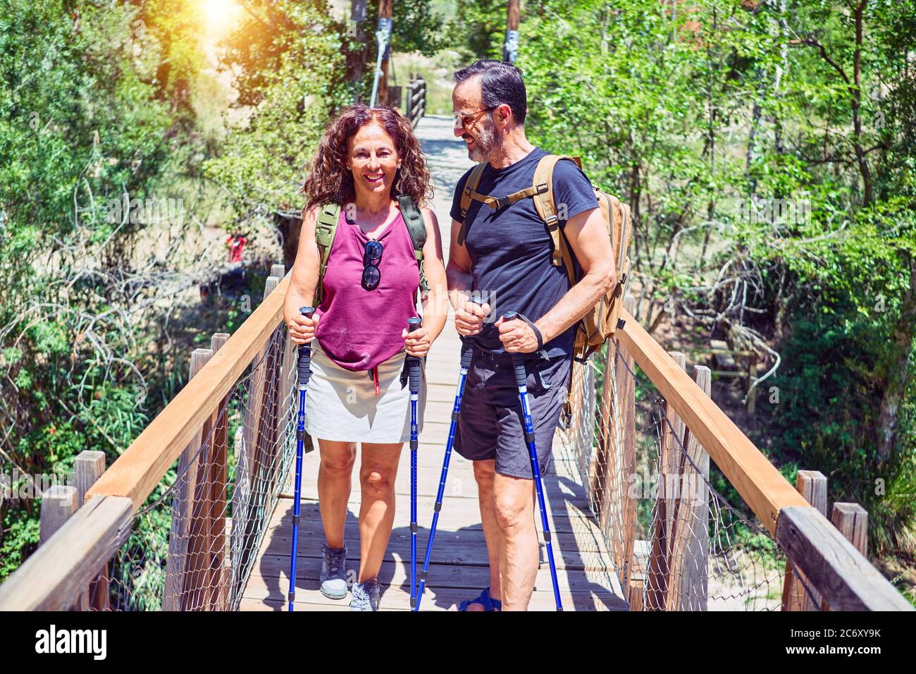 Beautiful couple of hiker wearing explorer clothes and backpack smiling ...