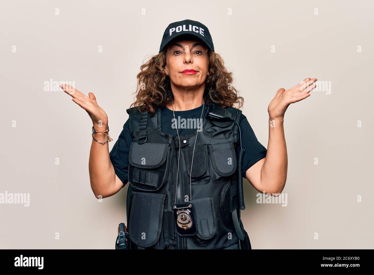 Middle age beautiful policewoman wearing bulletproof uniform and cap ...