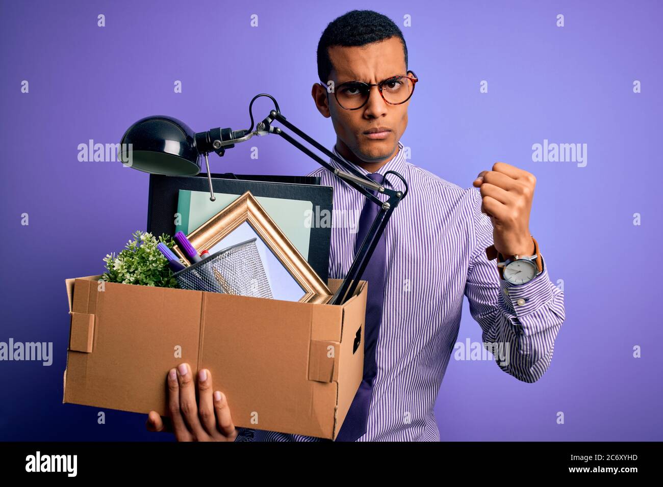 Handsome african american man fired holding box with work objects over ...
