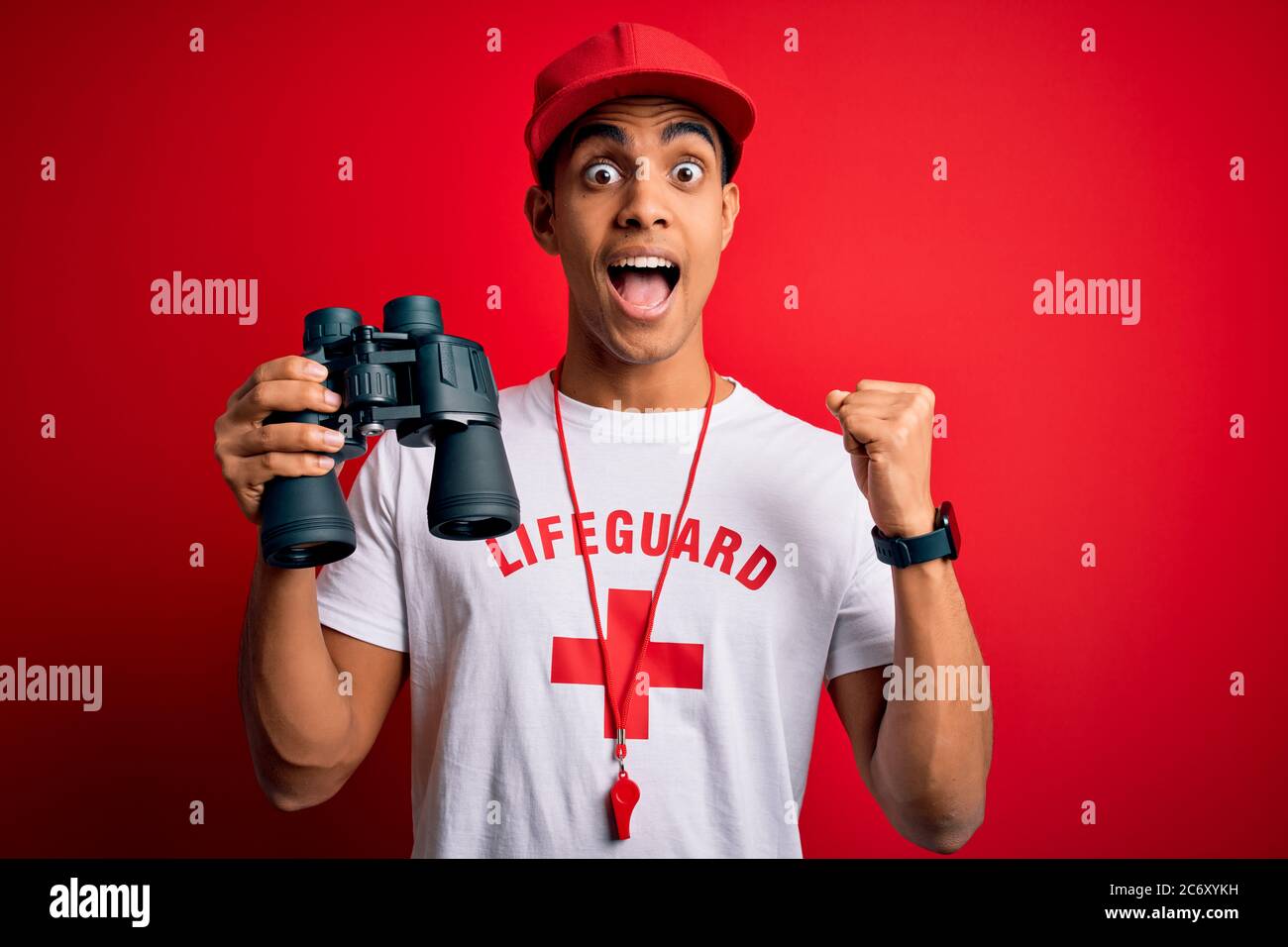 Young handsome african american lifeguard man wearing whistle using ...
