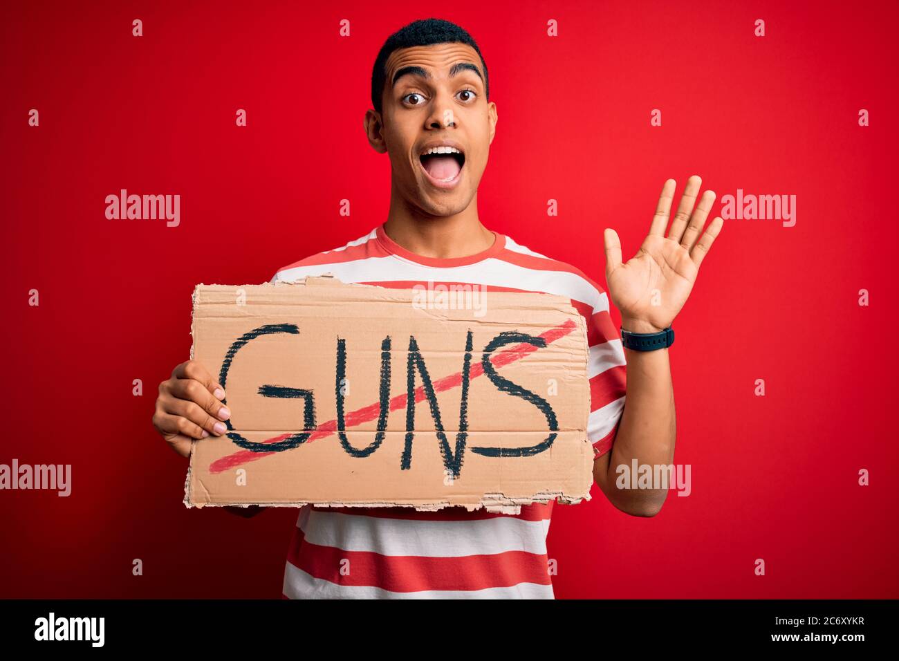 Young handsome african american man holding banner with prohibited guns ...