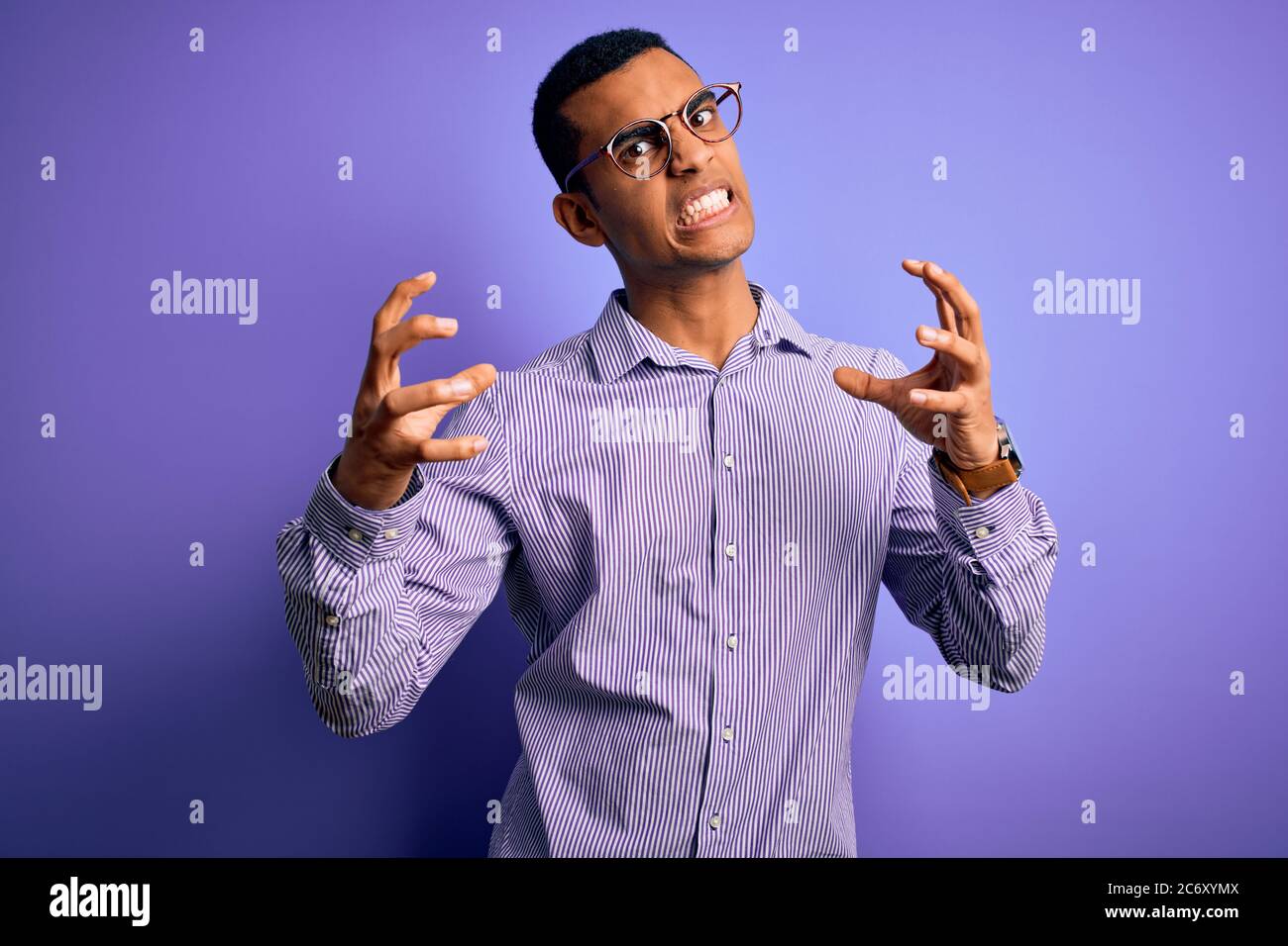Handsome african american man wearing striped shirt and glasses over ...