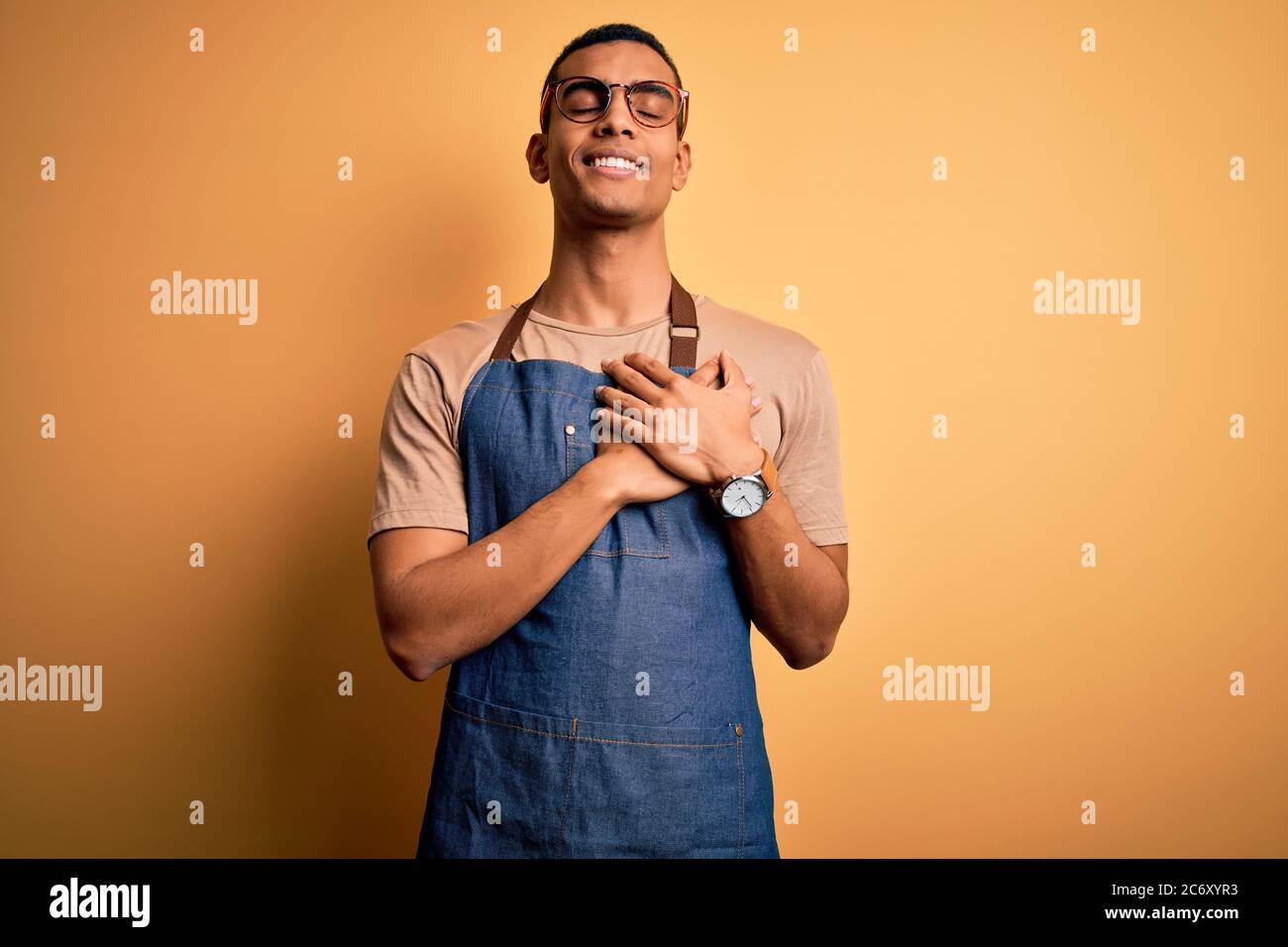 Young handsome african american shopkeeper man wearing apron over ...