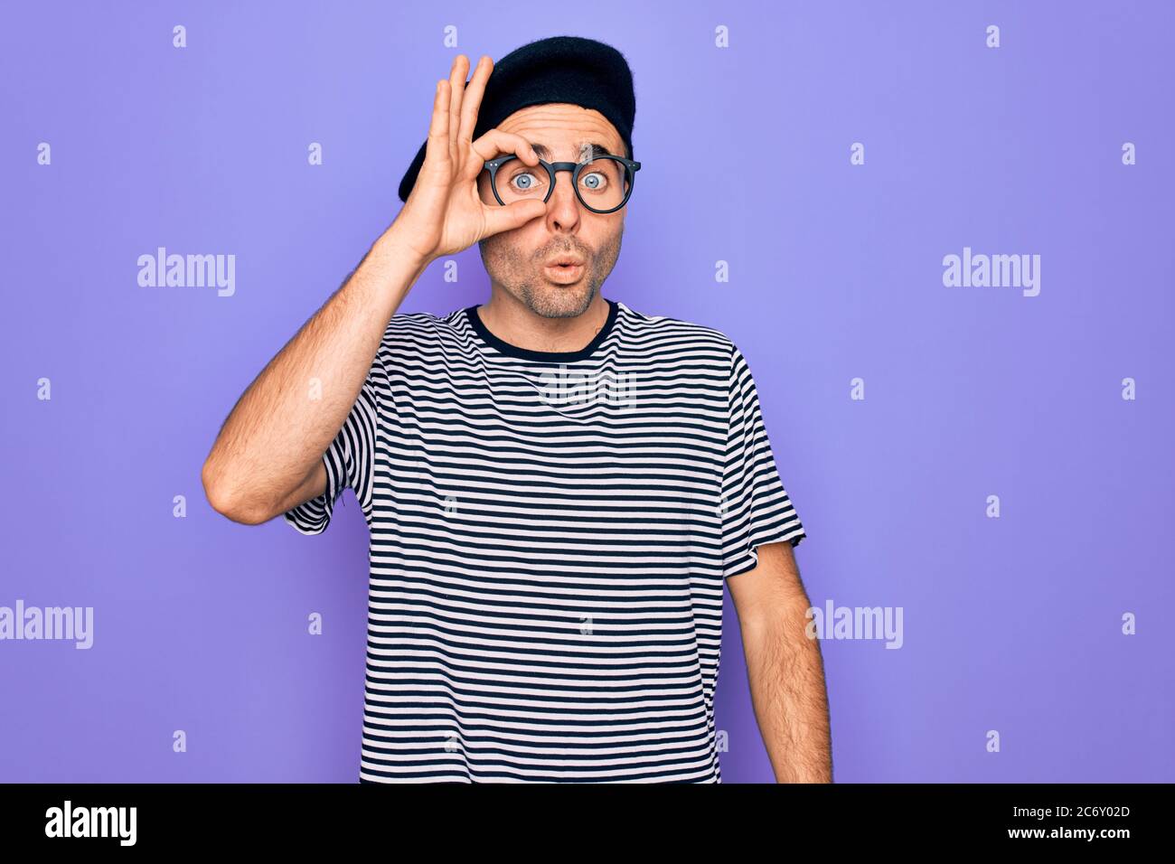 Handsome man with blue eyes wearing striped t-shirt and french beret ...