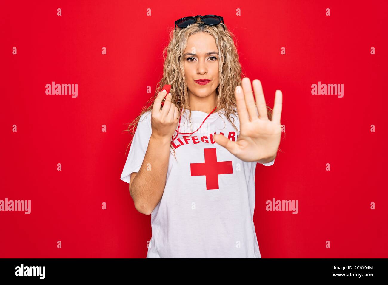 Young beautiful blonde lifeguard woman wearing t-shirt with red cross ...