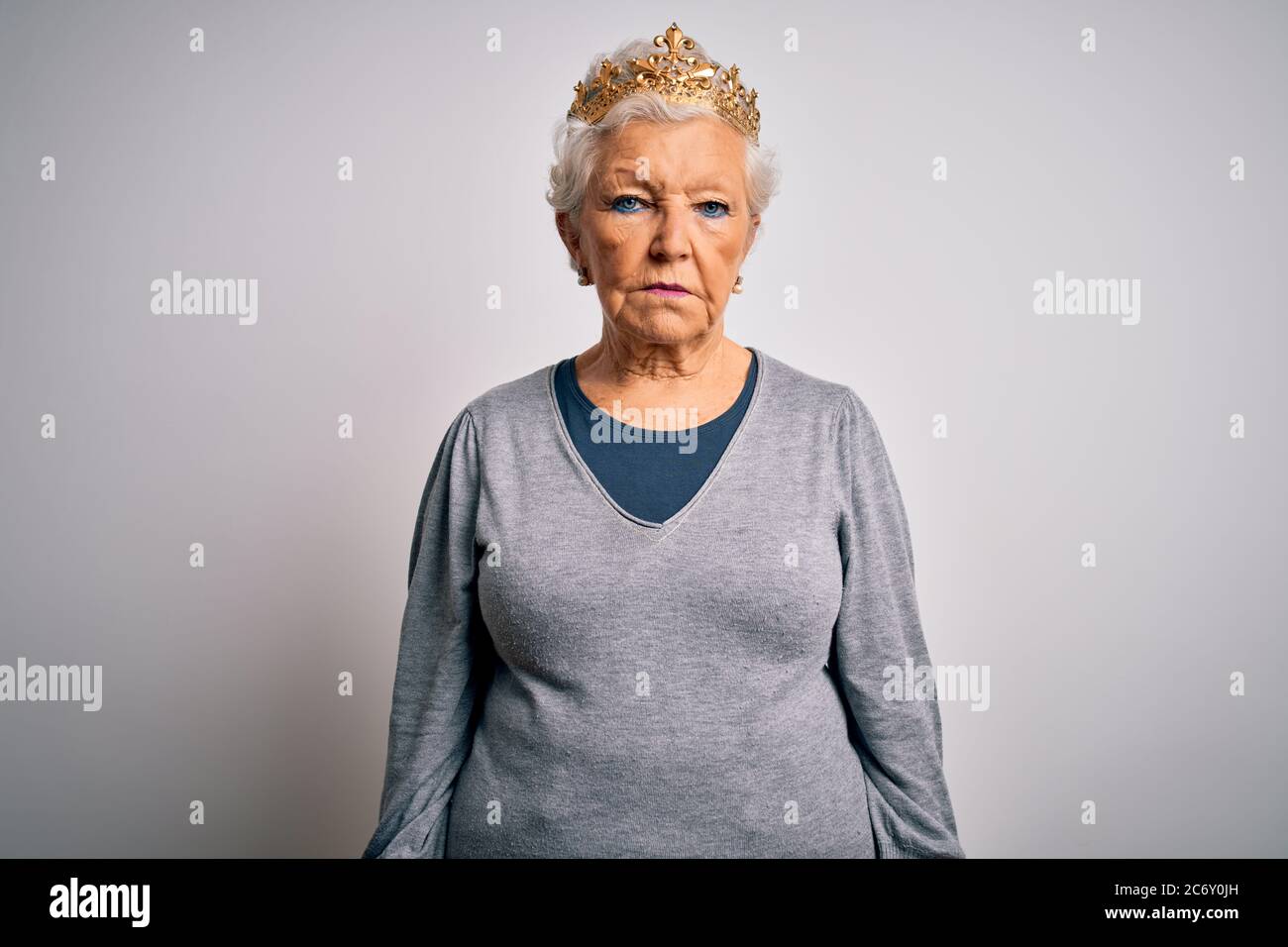 Senior beautiful grey-haired woman wearing golden queen crown over ...