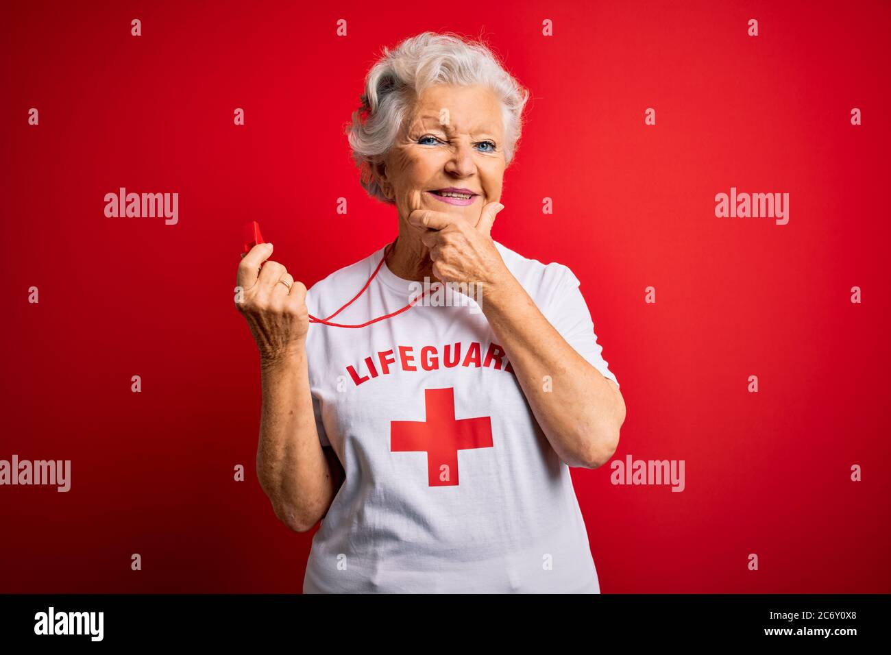 Senior beautiful grey-haired lifeguard woman wearing t-shirt with red ...