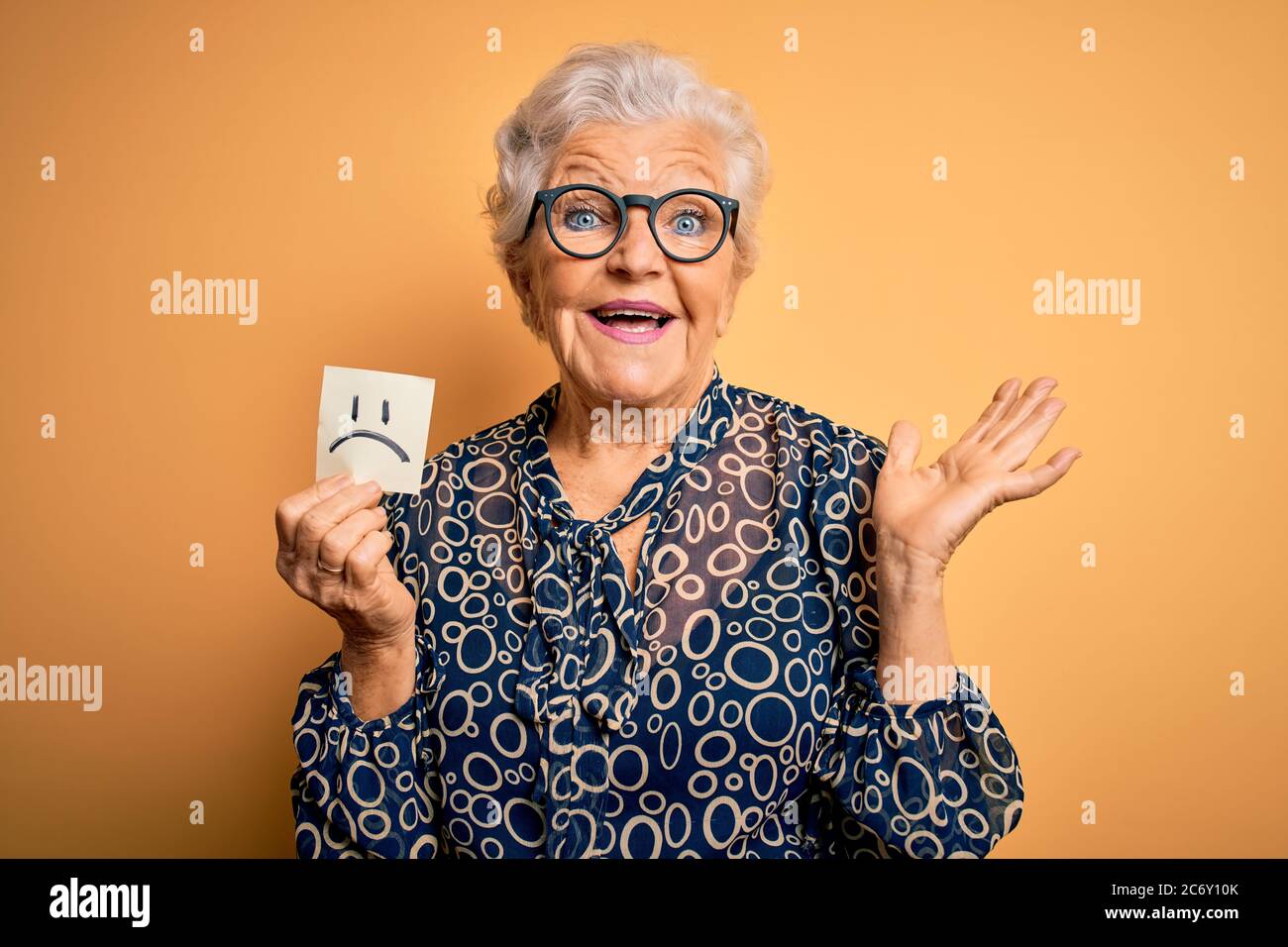 Senior beautiful grey-haired woman holding reminder paper with sad ...