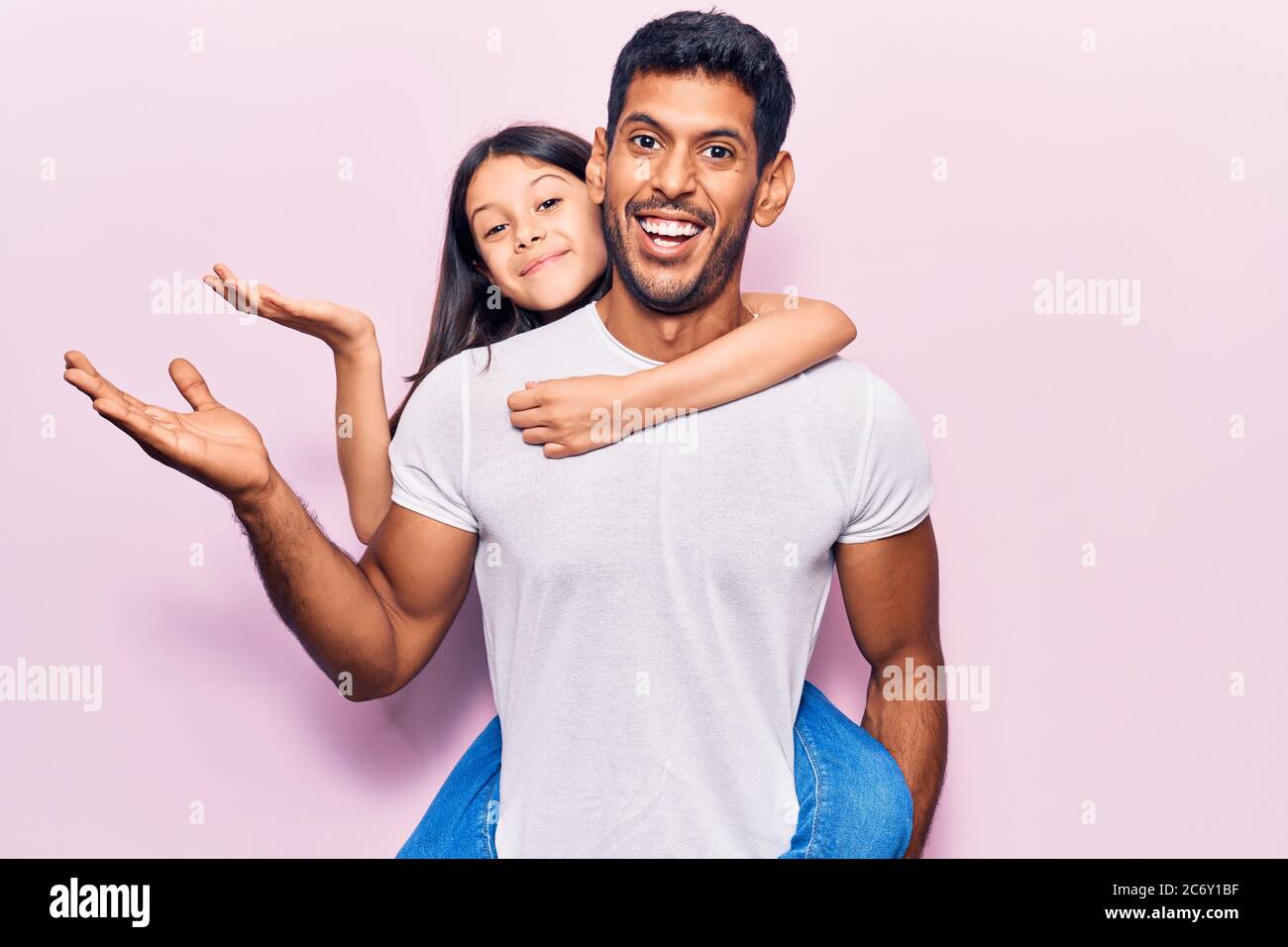 Latin father and daughter wearing casual clothes celebrating ...