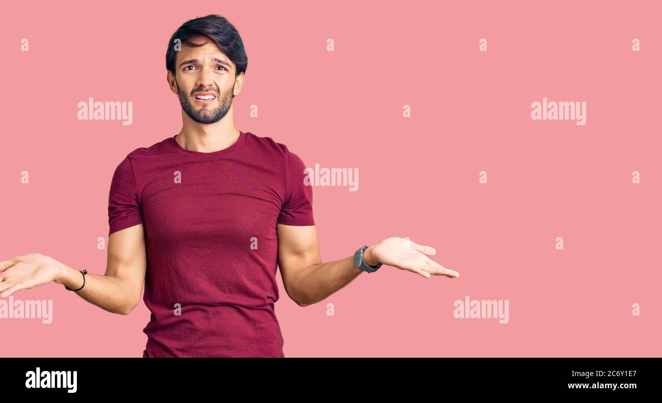 Handsome hispanic man wearing casual clothes clueless and confused with ...