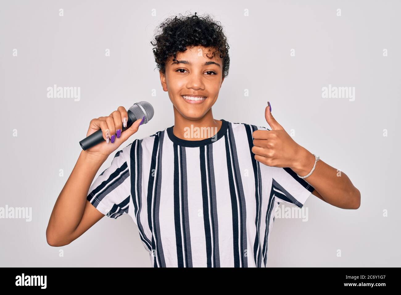 Beautiful african american afro singer woman singing using microphone ...