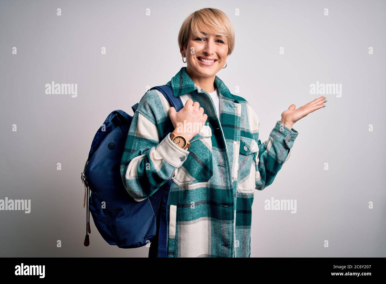 Young blonde woman with short hair wearing travel backpack over ...