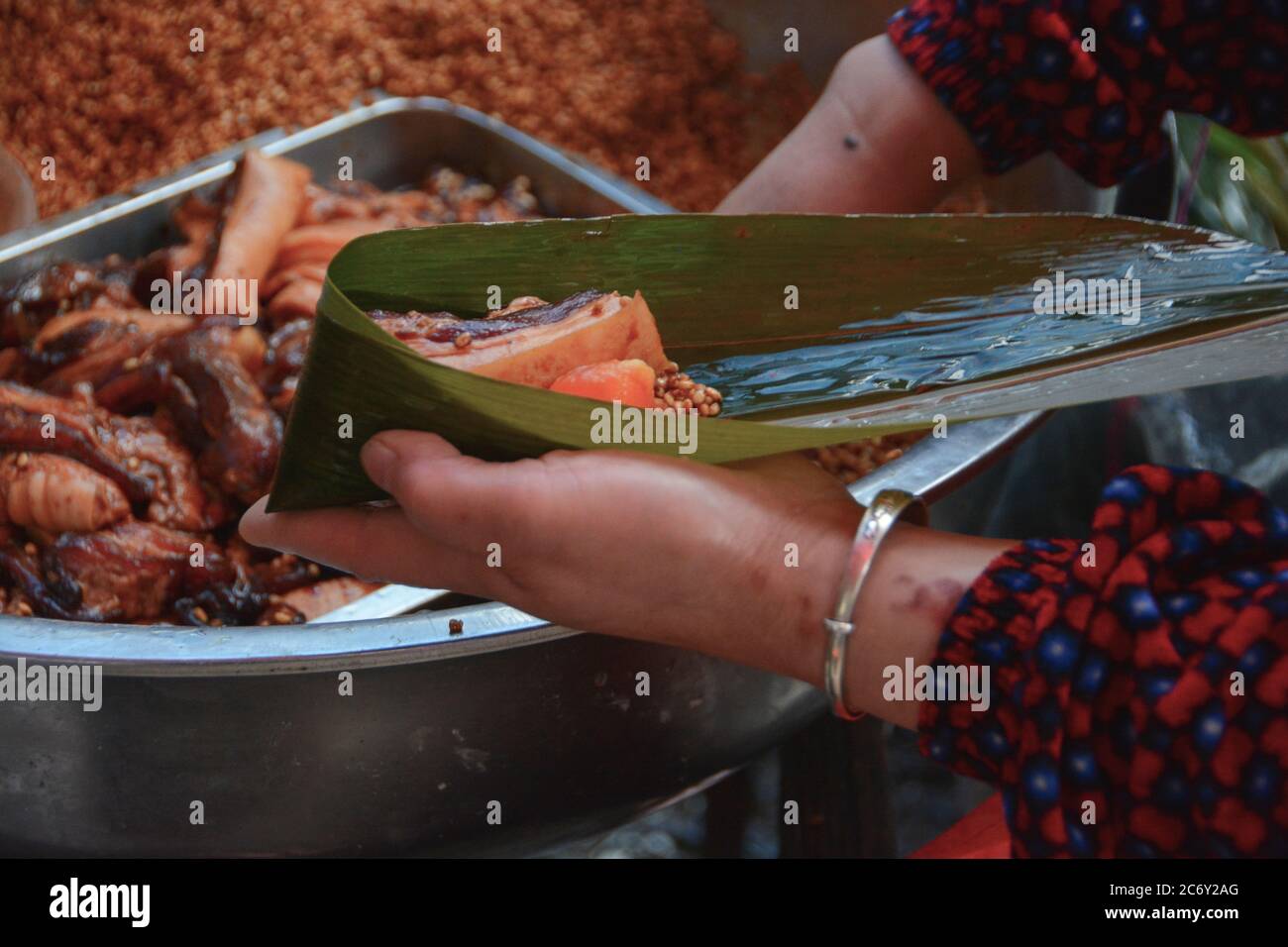 Vendors are busy at making zongzis, a traditional Chinese rice dish ...