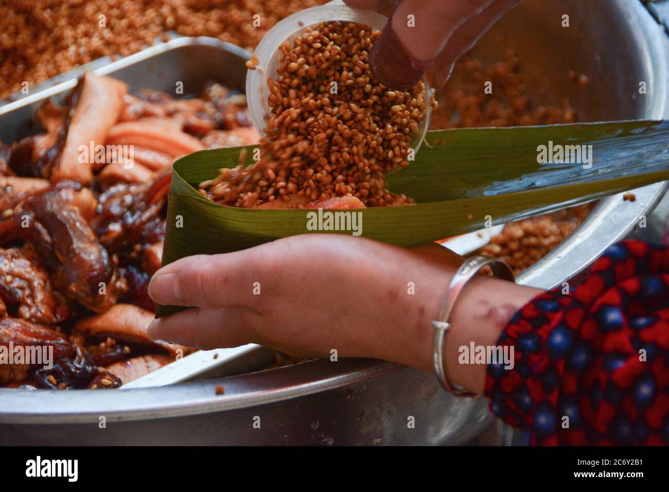 Vendors are busy at making zongzis, a traditional Chinese rice dish ...