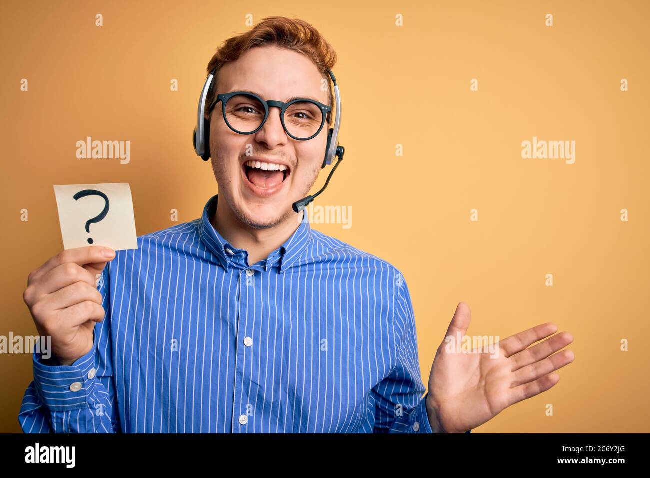 Redhead call center agent man working using headset holding reminder ...