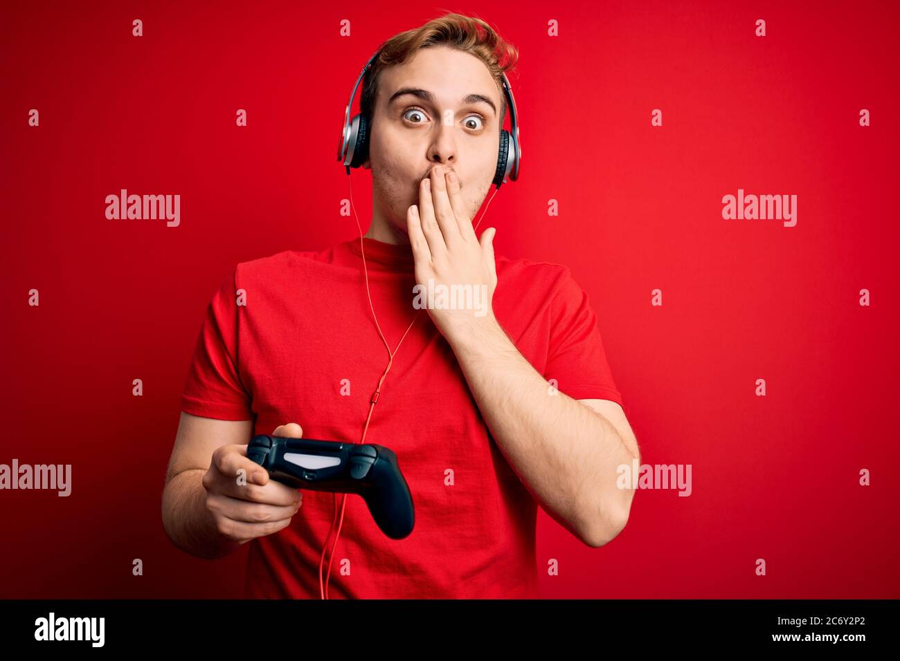 Young handsome redhead gamer man playing video game using headphones ...