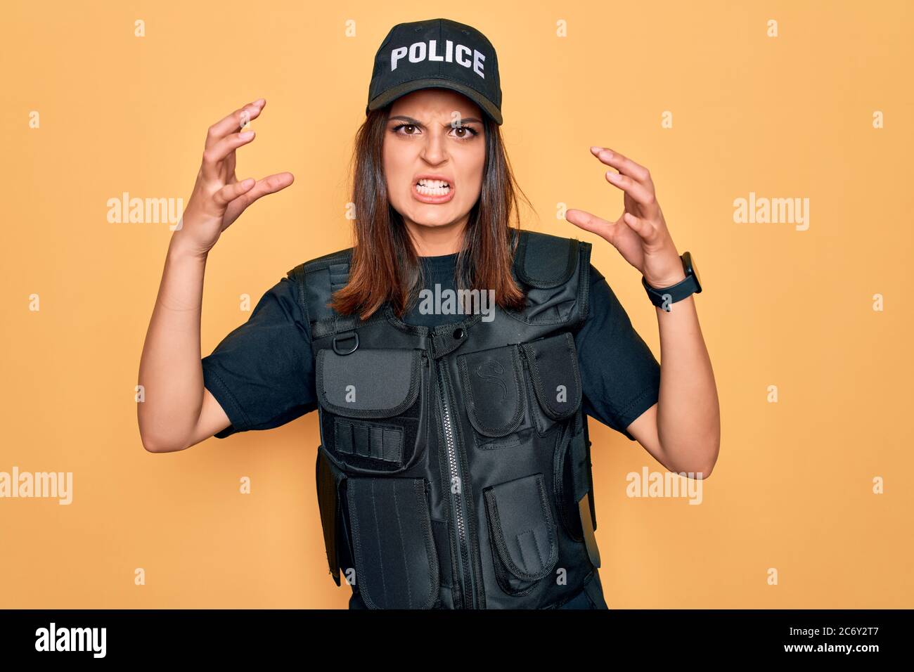 Young beautiful brunette policewoman wearing police uniform bulletproof ...