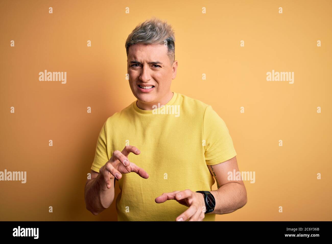 Young handsome modern man wearing yellow shirt over yellow isolated ...