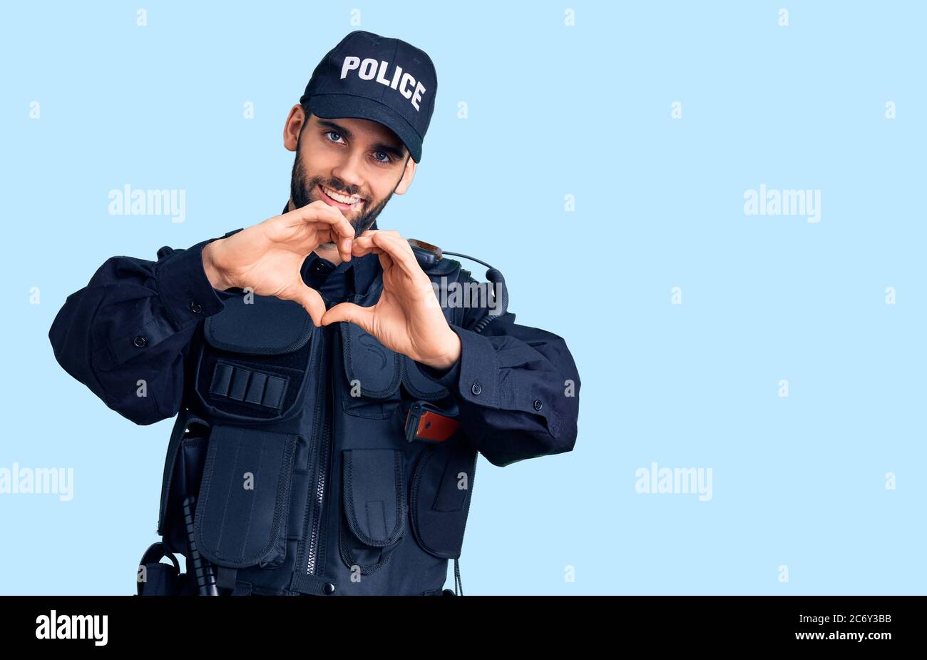 Young handsome man with beard wearing police uniform smiling in love ...