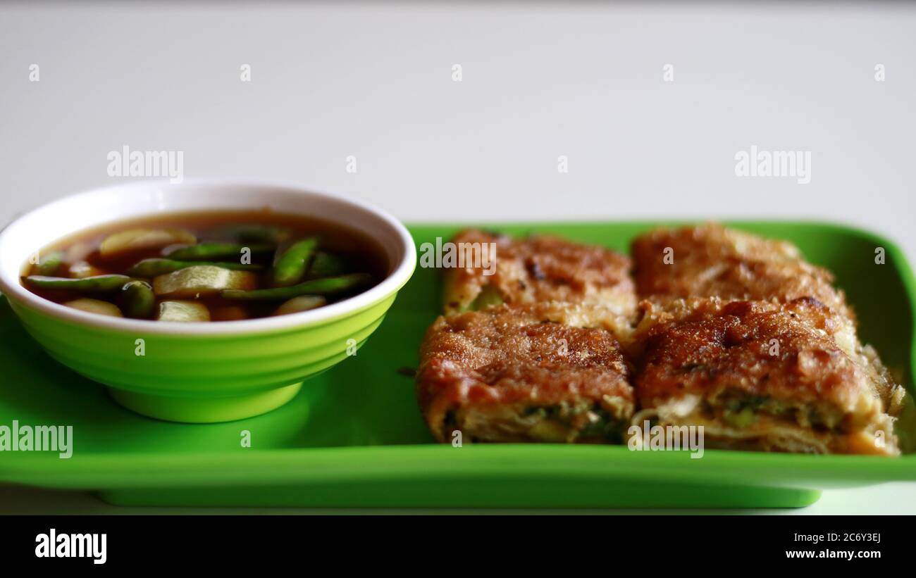 Martabak Telur. A square crepes filled with mixture of egg, green onion ...