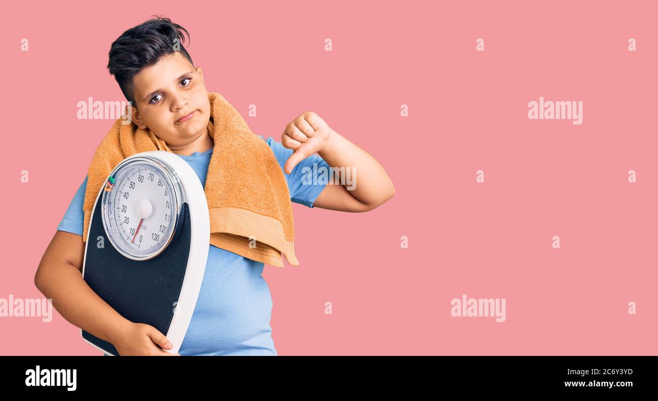 Little boy kid holding weight machine to balance weight loss with angry ...