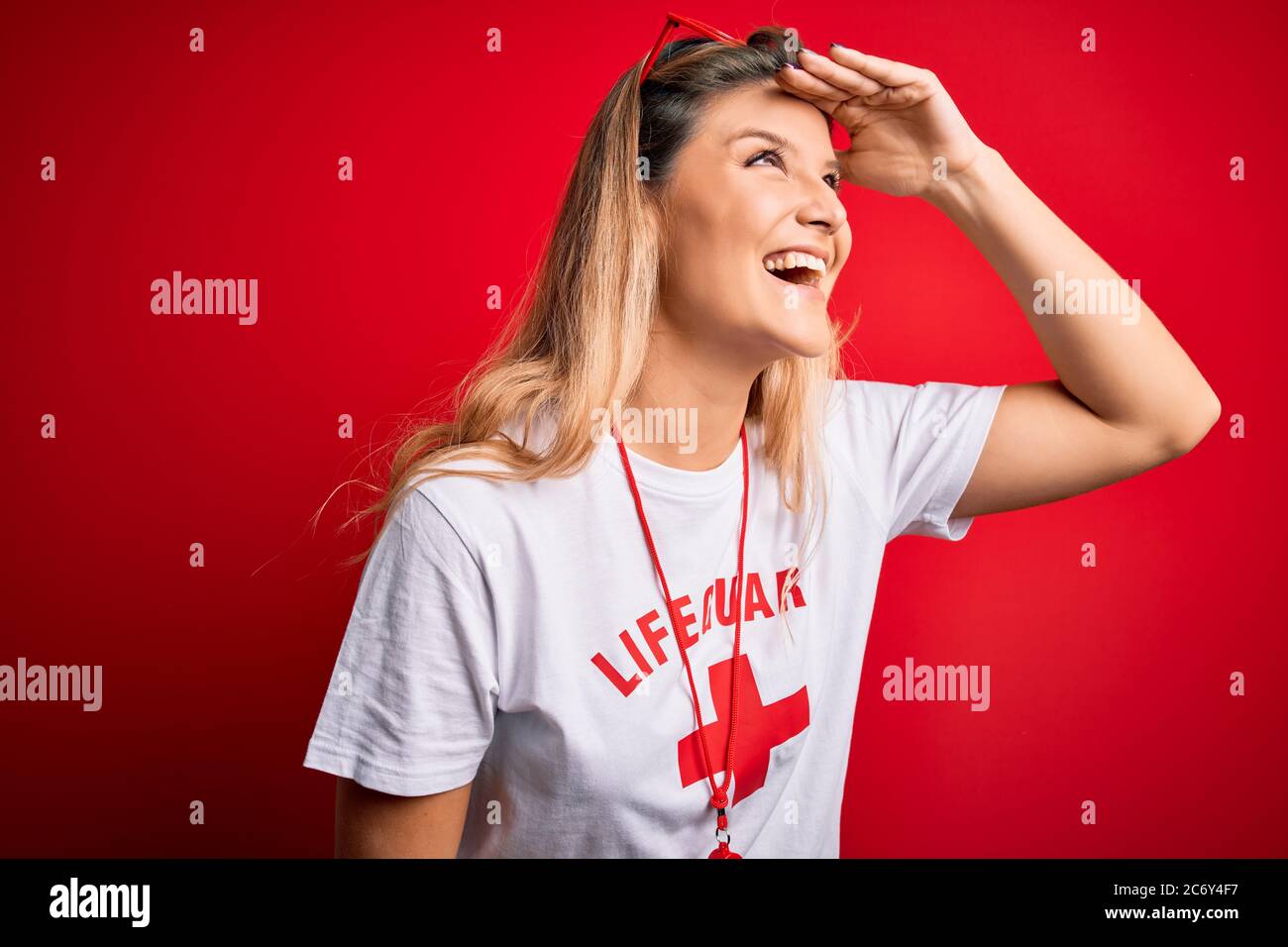 Young beautiful blonde lifeguard woman wearing t-shirt with red cross ...