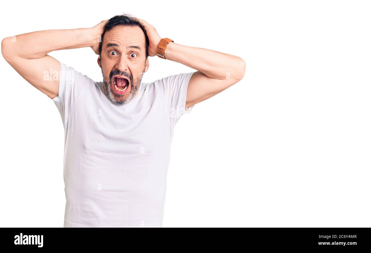 Middle age handsome man wearing casual t-shirt crazy and scared with ...
