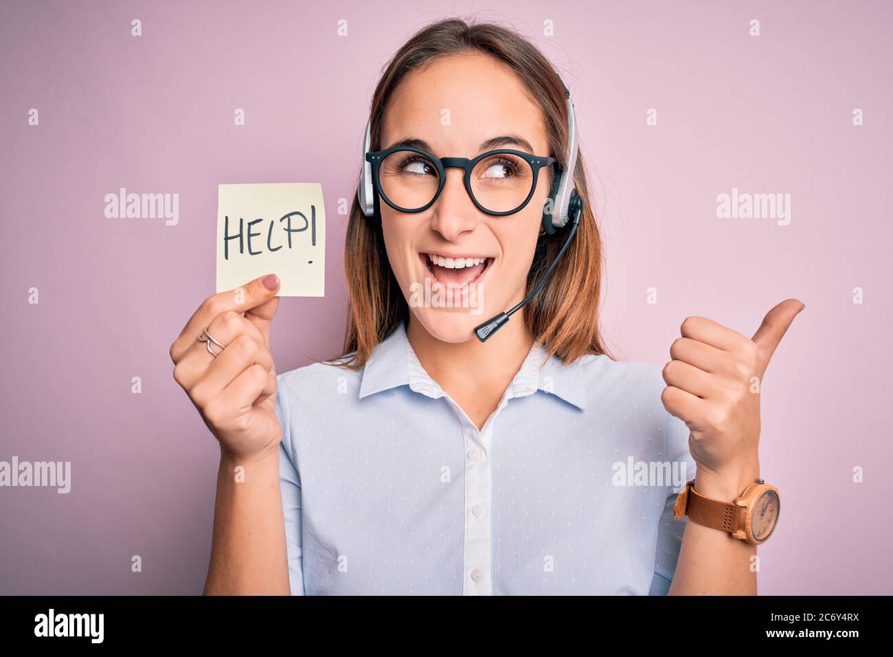 Beautiful call center agent woman working using headset holding help ...