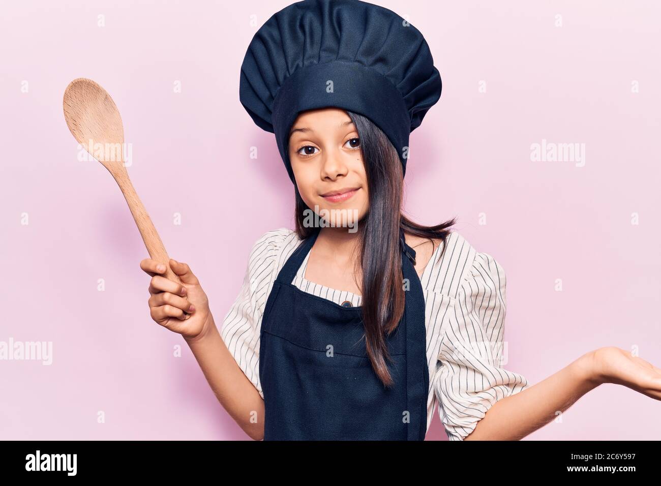 Beautiful child girl wearing cooker uniform celebrating achievement ...