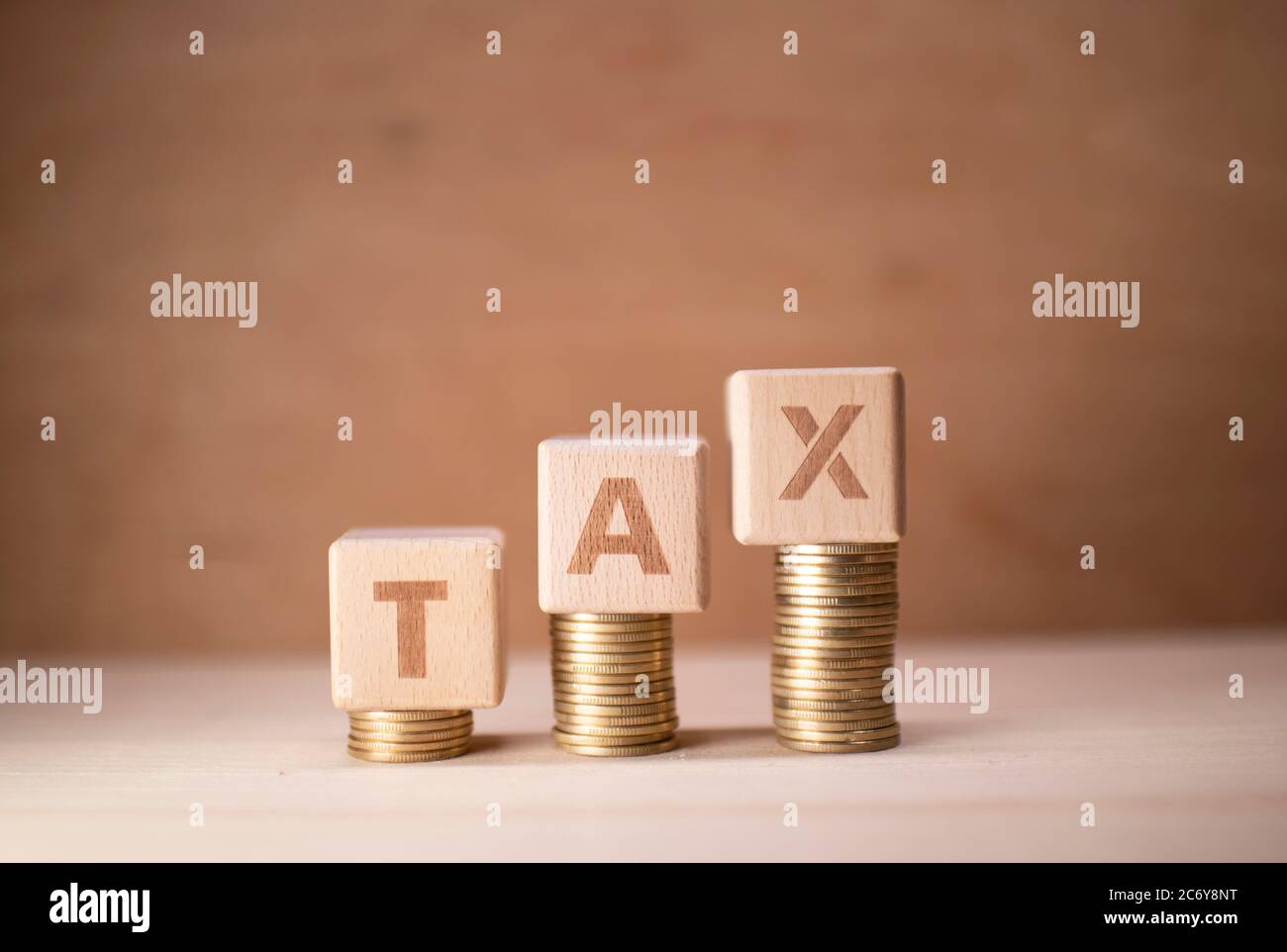 Tax increase illustrated with wooden cubes and coins Stock Photo - Alamy